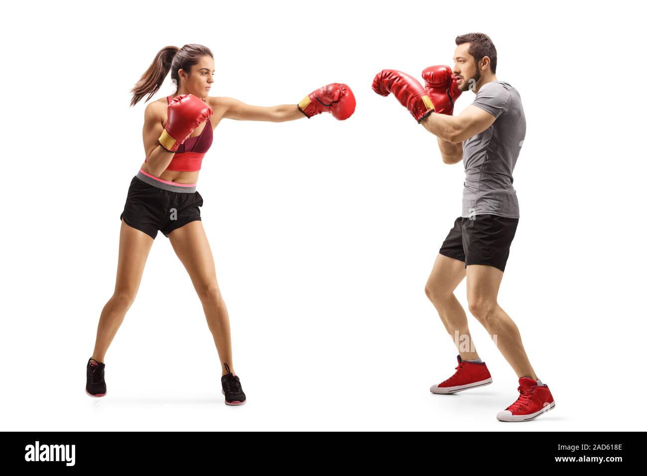 Full length shot of a young man and woman fighting with boxing gloves ...