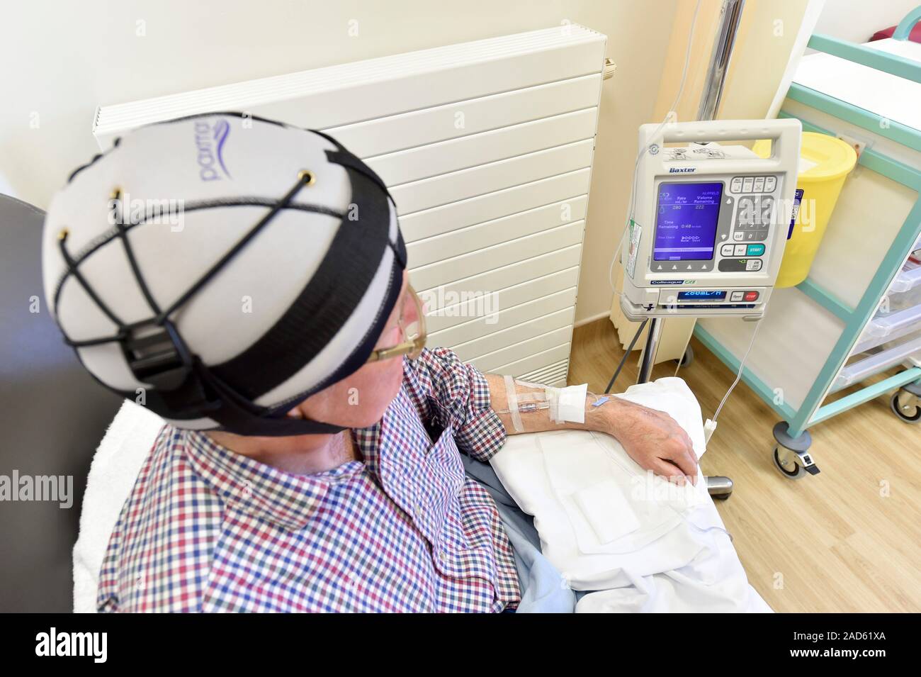 Prostate cancer chemotherapy. Cooling cap being worn by a 65-year-old ...