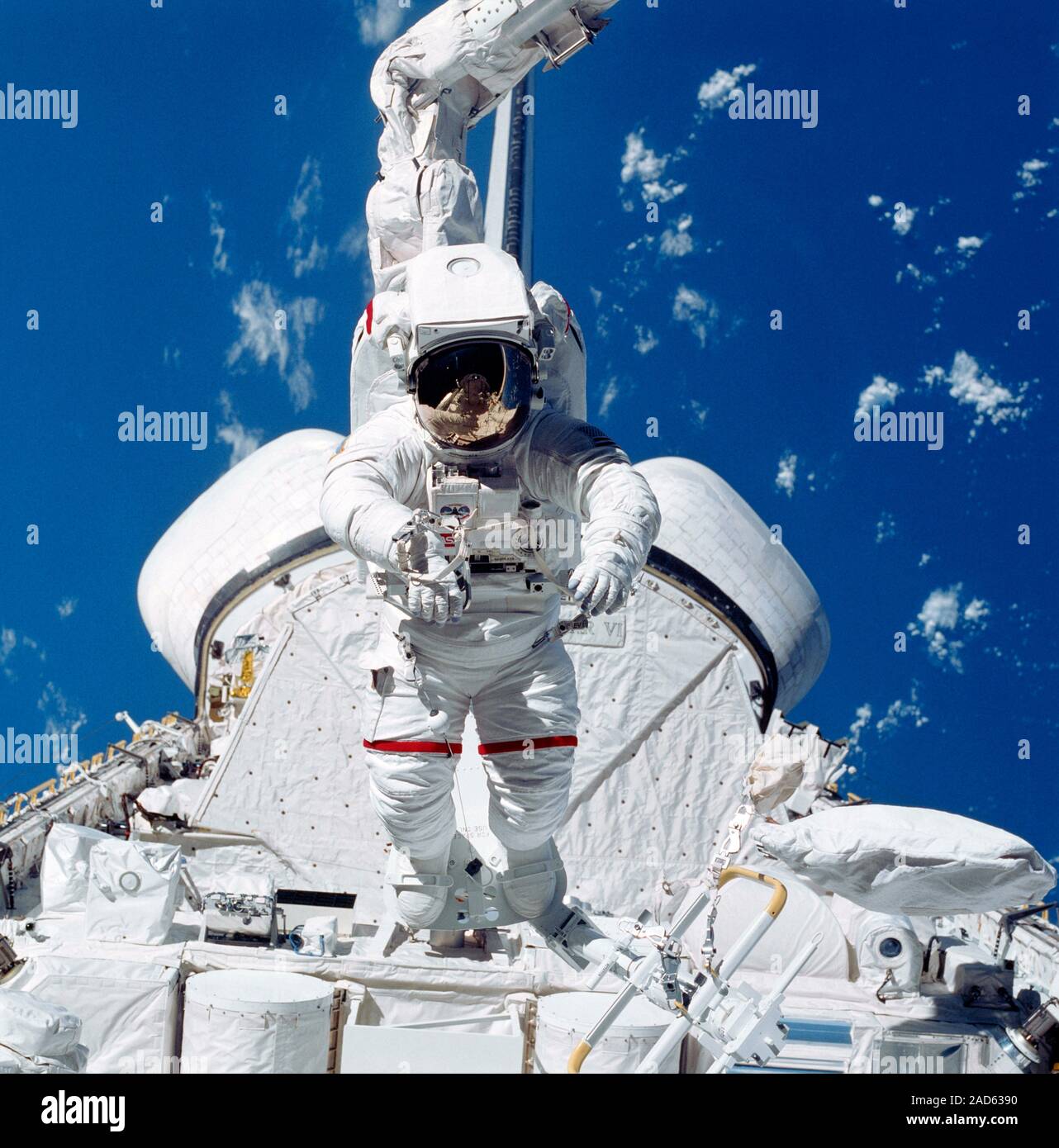 Astronaut Bruce McCandless riding on the Remote Manipulator System (RMS ...