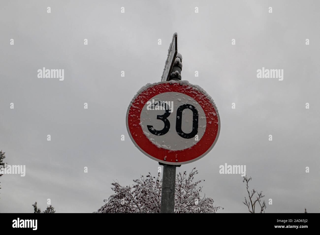 Snow on a traffic sign with 30 as number Stock Photo - Alamy