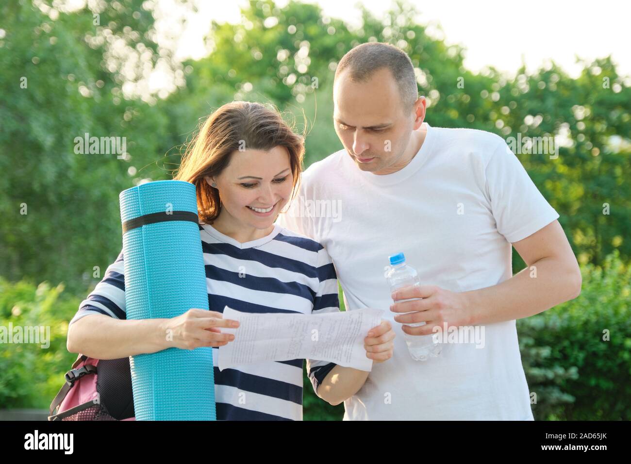Mature couple reading paper document letter outdoor Stock Photo - Alamy
