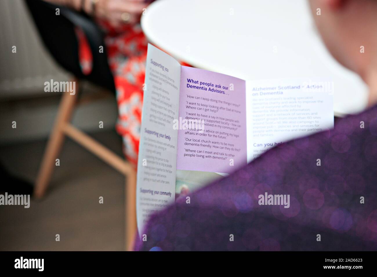 Dementia information leaflet. Woman with dementia reading an ...