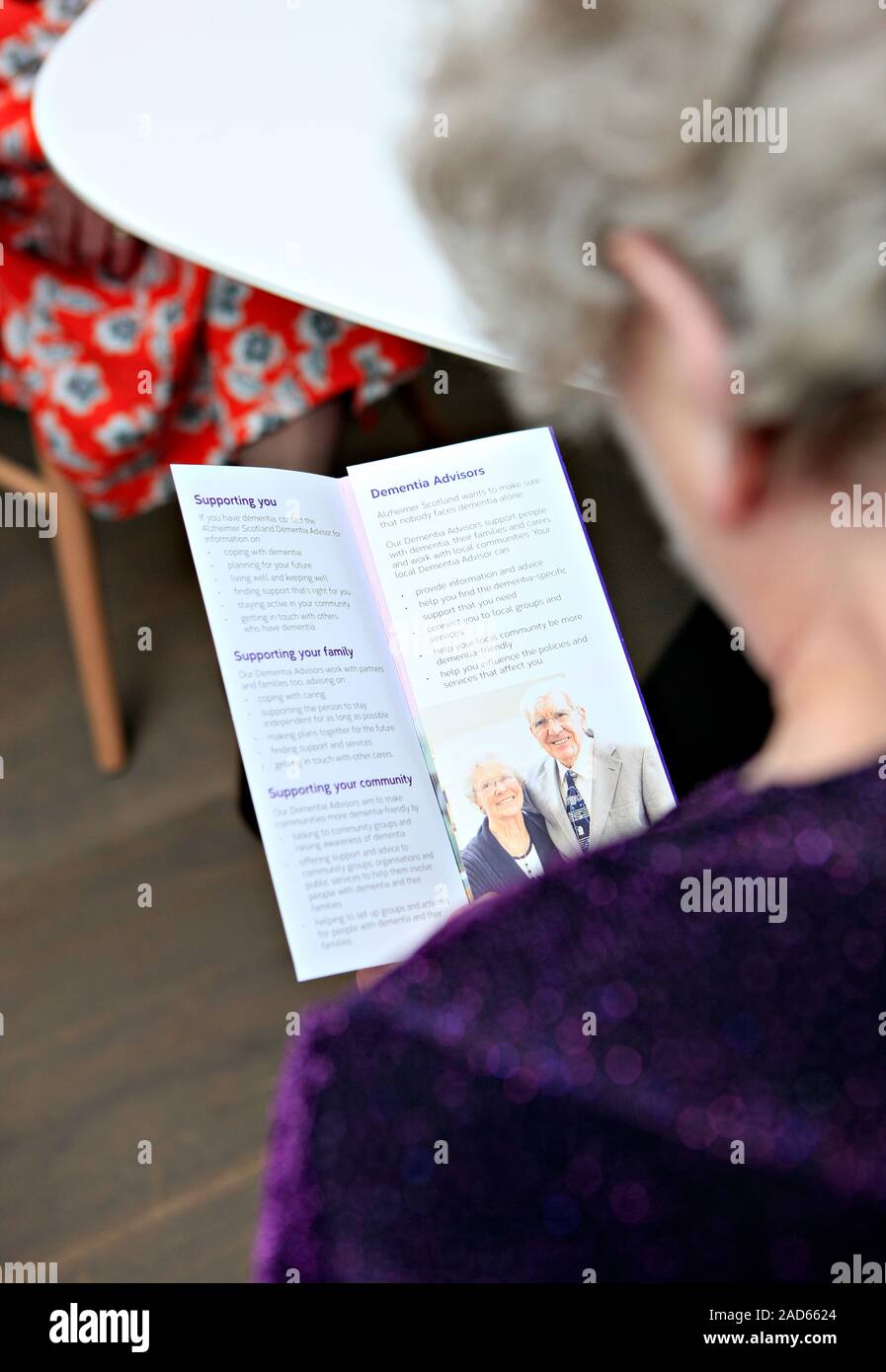 Dementia information leaflet. Woman with dementia reading an ...