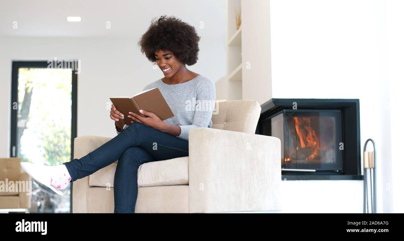 black woman at home reading book Stock Photo - Alamy