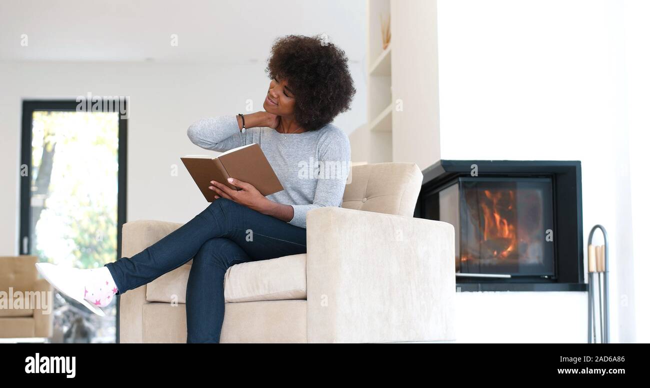 black woman at home reading book Stock Photo - Alamy