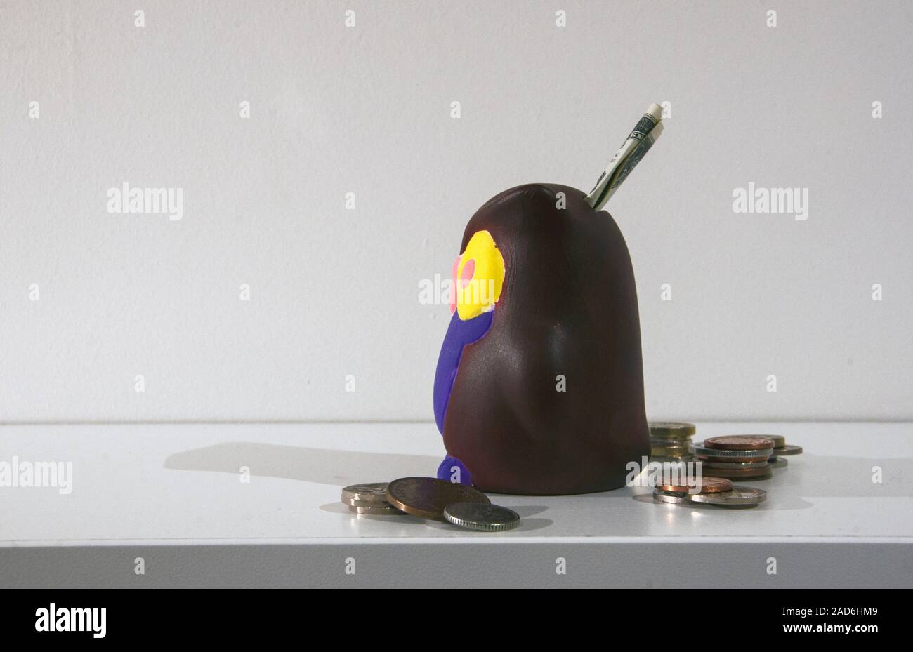 An owl-shaped savings pot / "piggy bank" with coins and bank notes ...