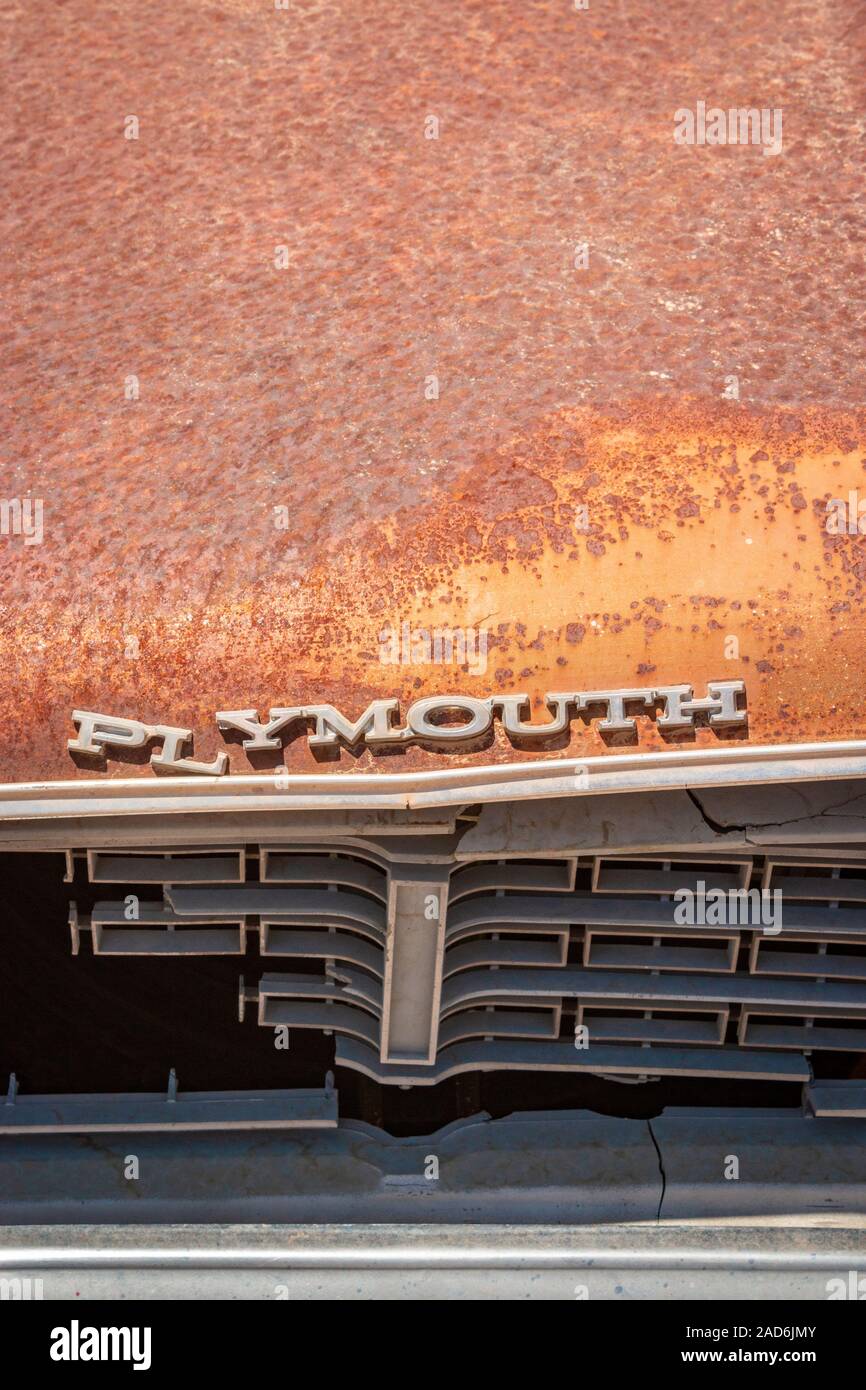 rusty old Plymouth car in a junk yard in the desert in Phoenix Arizona ...