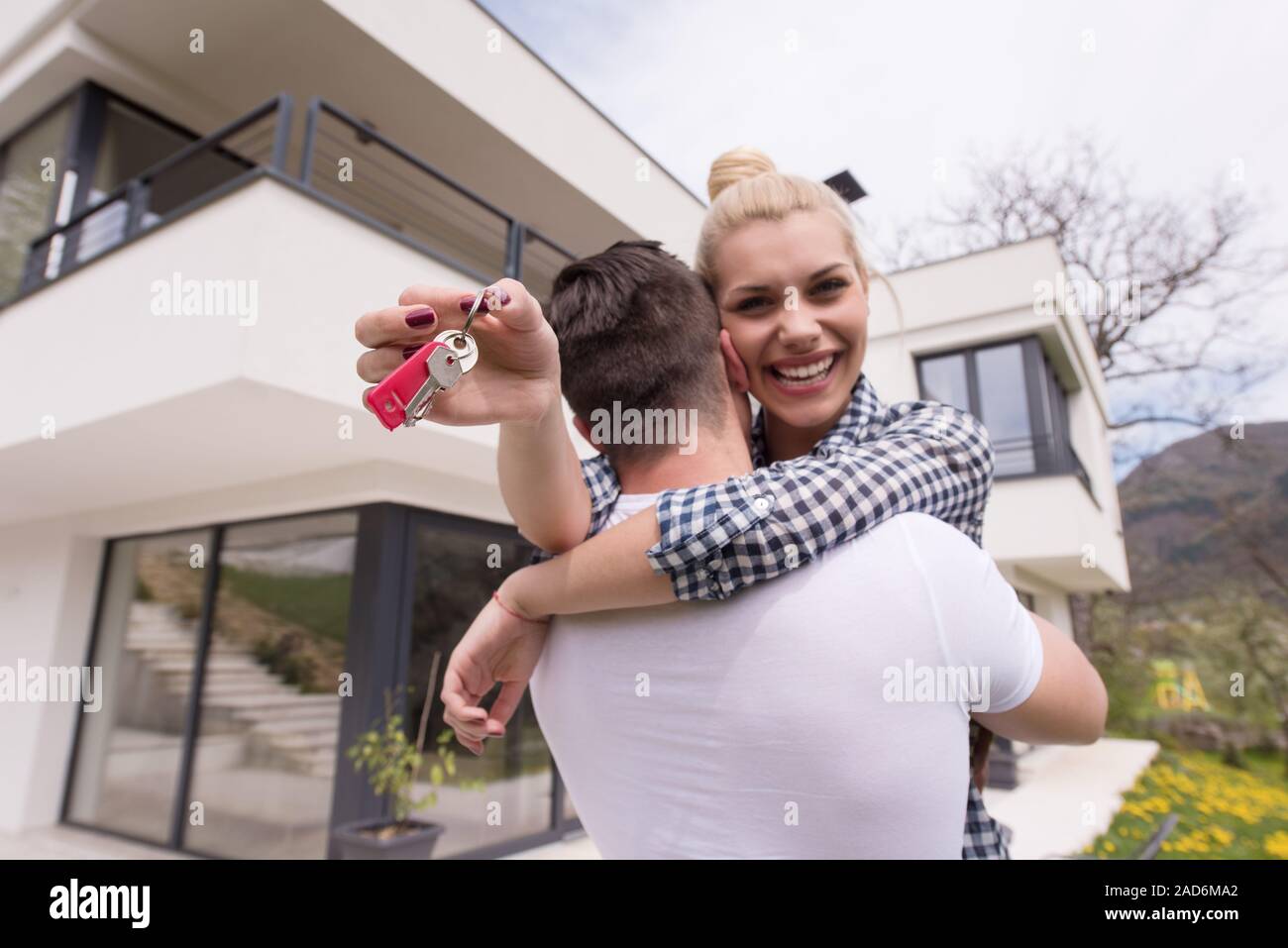 couple hugging in front of new luxury home Stock Photo - Alamy