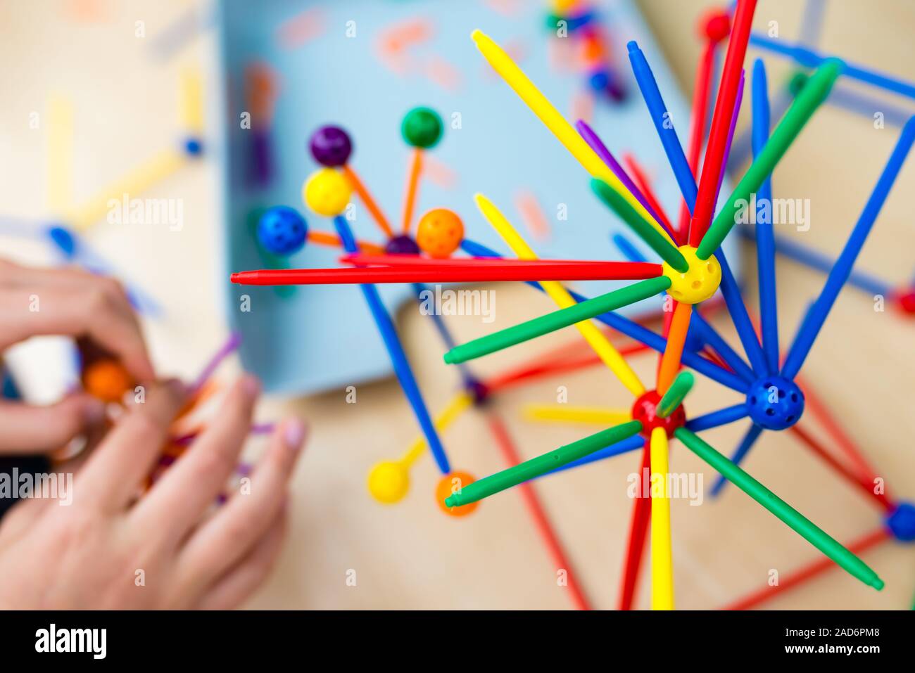 Two little girls playing with lots of colorful plastic sticks kit ...