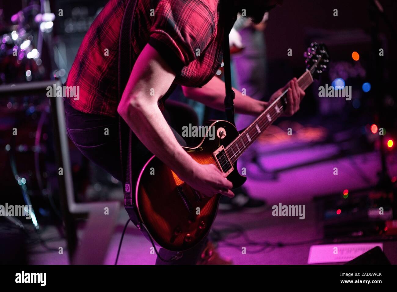 Rock band performs on stage. Guitarist, bass guitar and drums. The ...