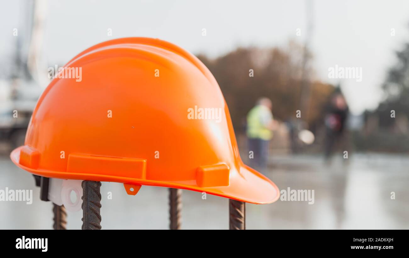 Orange safety helmet at construction site with blurry background Stock ...