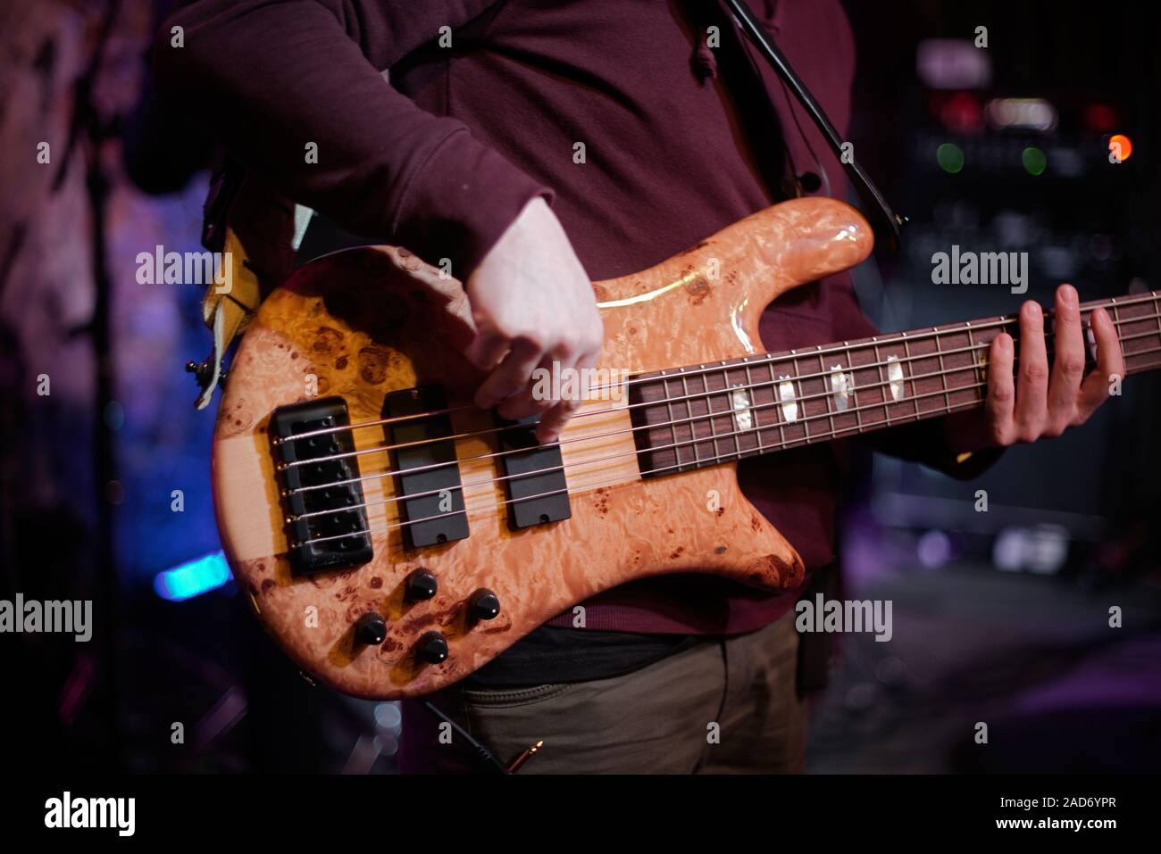 Rock band performs on stage. Guitarist, bass guitar and drums. The ...