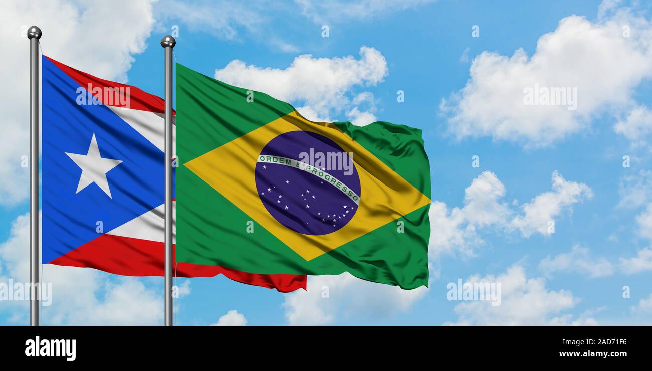 Puerto Rico and Brazil flag waving in the wind against white cloudy ...