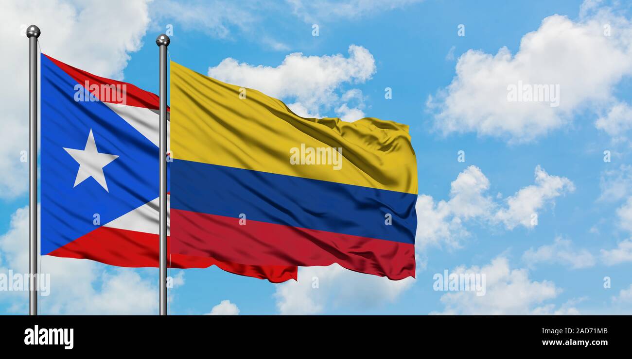 Puerto Rico and Colombia flag waving in the wind against white cloudy ...