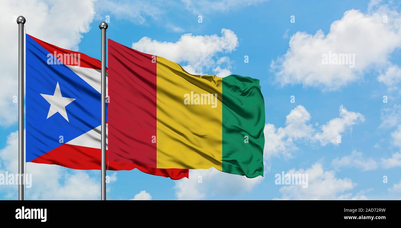 Puerto Rico and Guinea flag waving in the wind against white cloudy ...