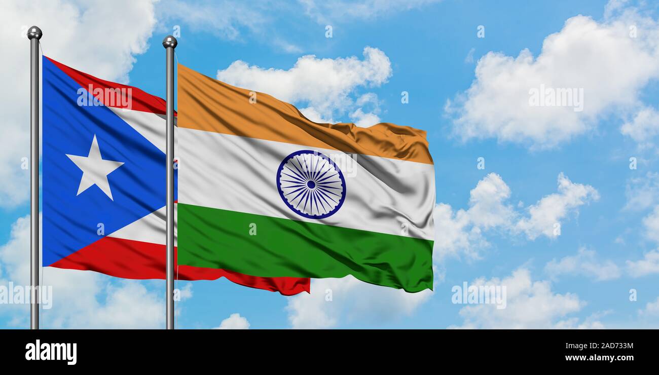 Puerto Rico and India flag waving in the wind against white cloudy blue ...