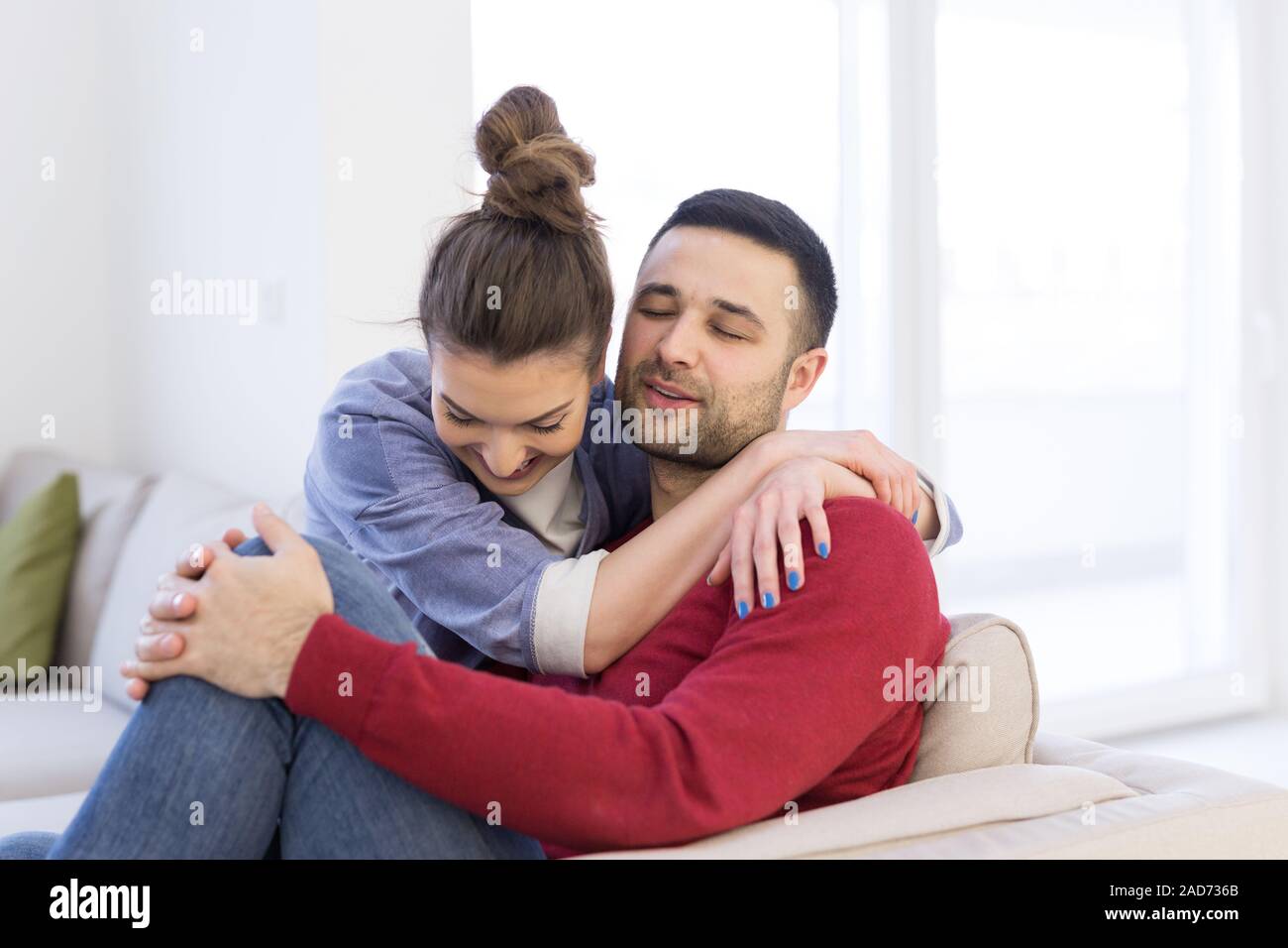 couple hugging and relaxing on sofa Stock Photo - Alamy