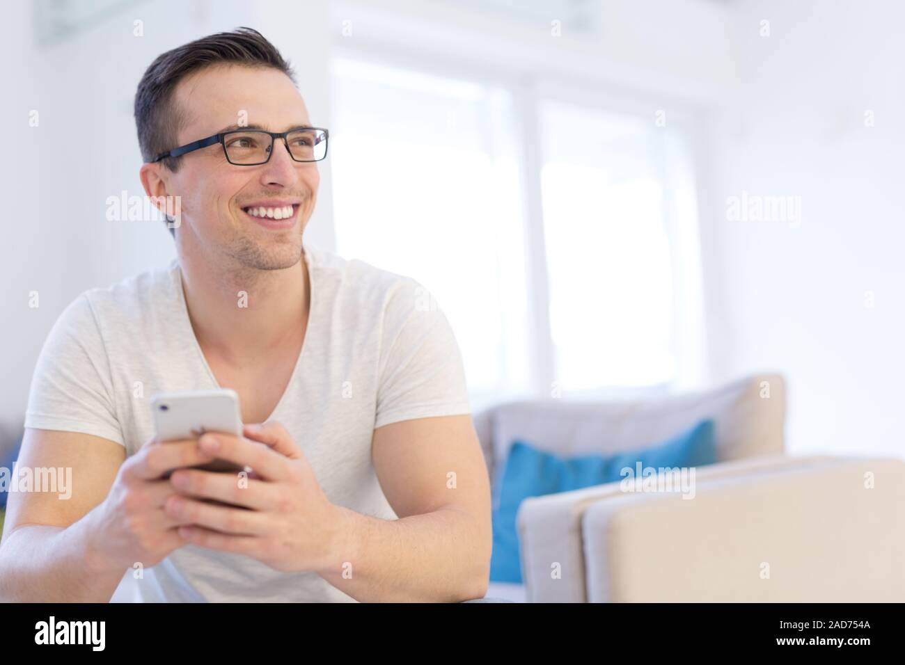 young man using a mobile phone at home Stock Photo - Alamy