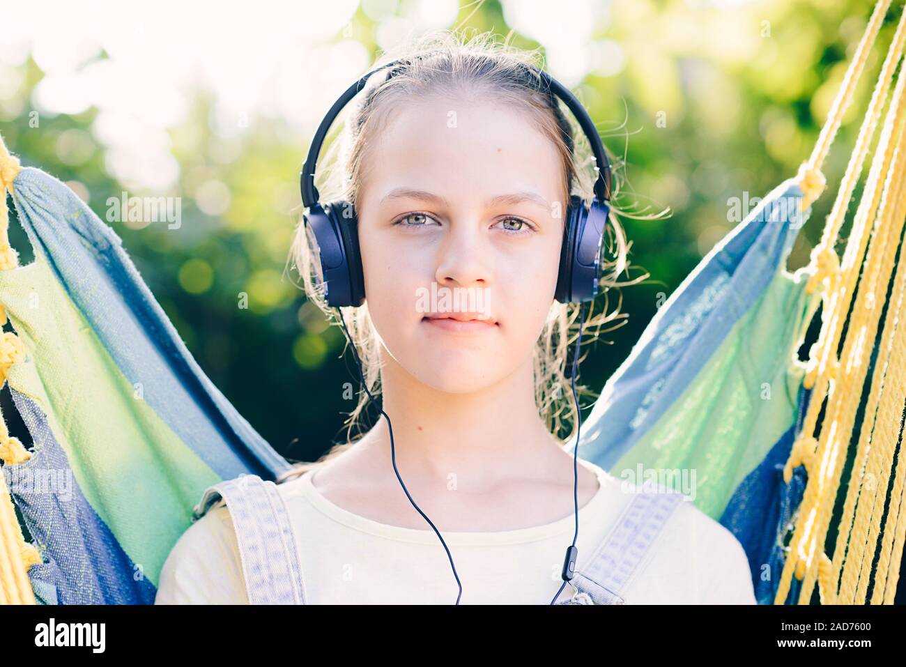 Cute girl listening to music with headphones outdoor - looking at ...