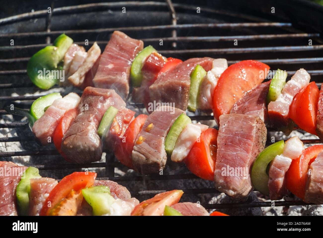 Beef brochettes grilling on the grid of a barbecue Stock Photo - Alamy