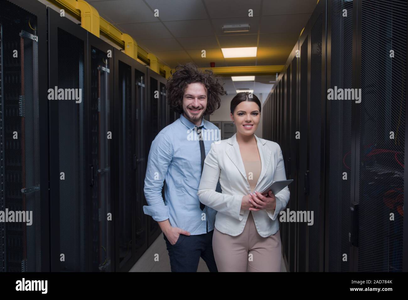 engineer showing working data center server room to female chief Stock ...