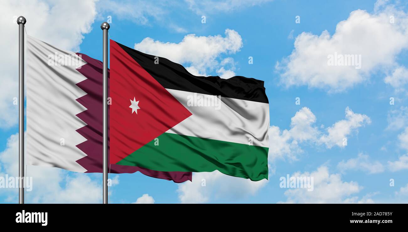 Qatar and Jordan flag waving in the wind against white cloudy blue sky ...