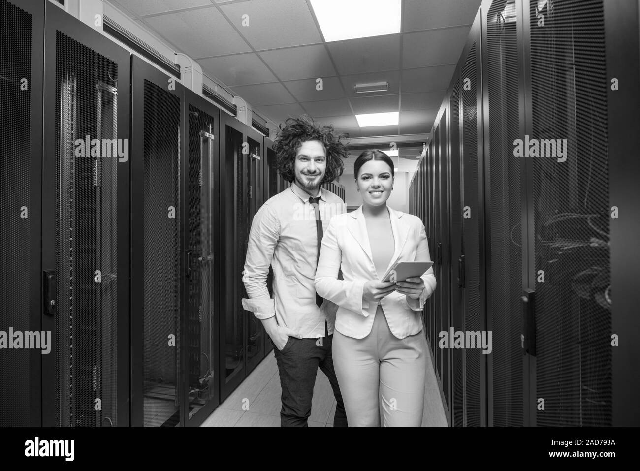 engineer showing working data center server room to female chief Stock ...
