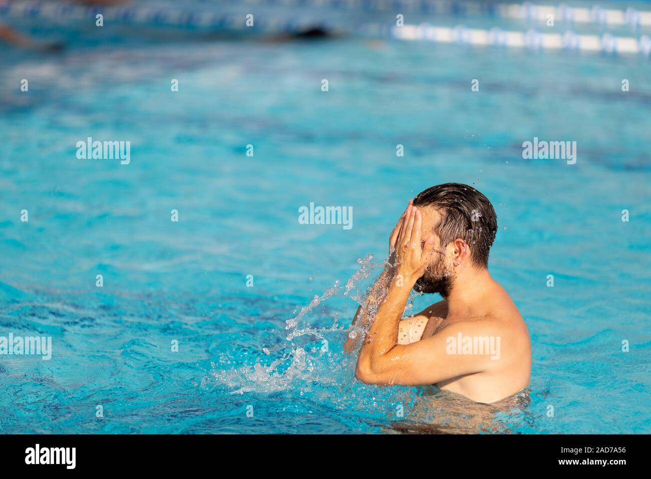 man in the pool face spray. Rest and travel concept Stock Photo - Alamy