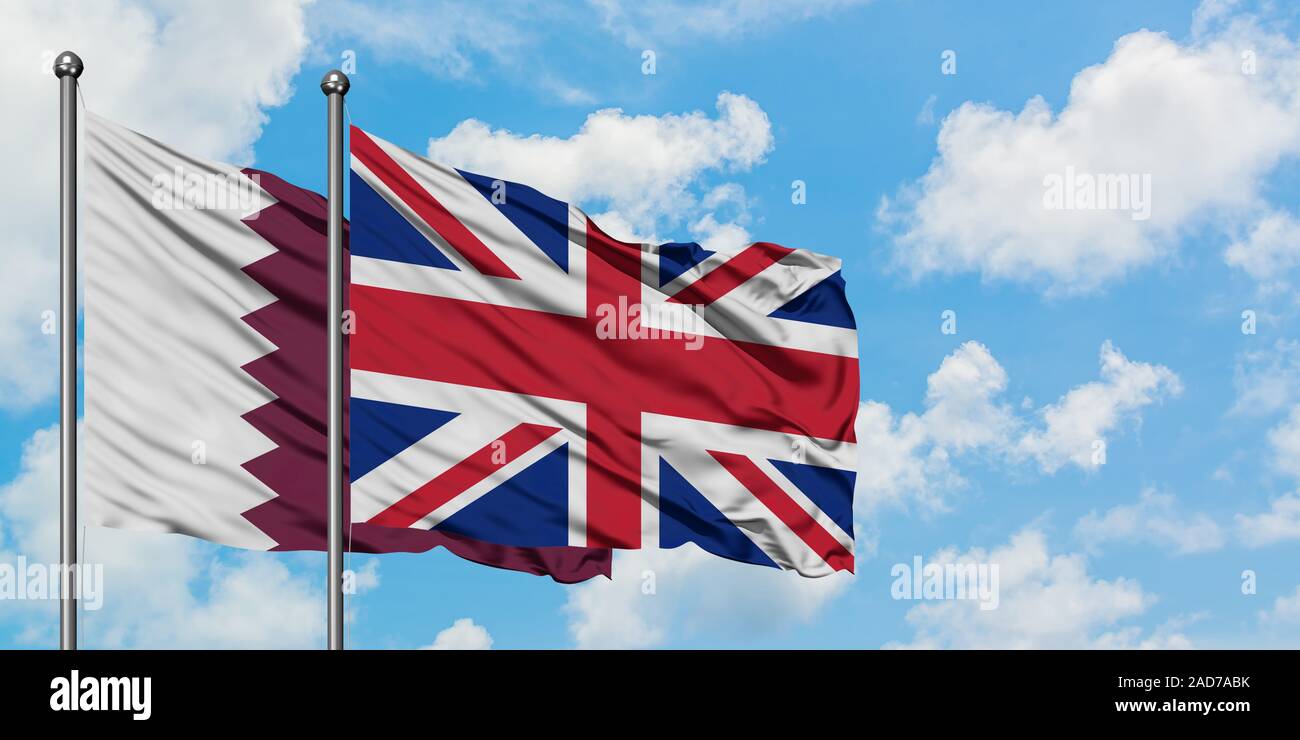 Qatar and United Kingdom flag waving in the wind against white cloudy ...