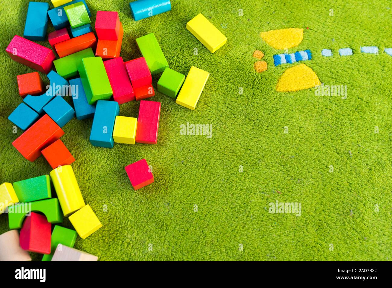 Colorful wooden blocks for children on green carpet Stock Photo - Alamy