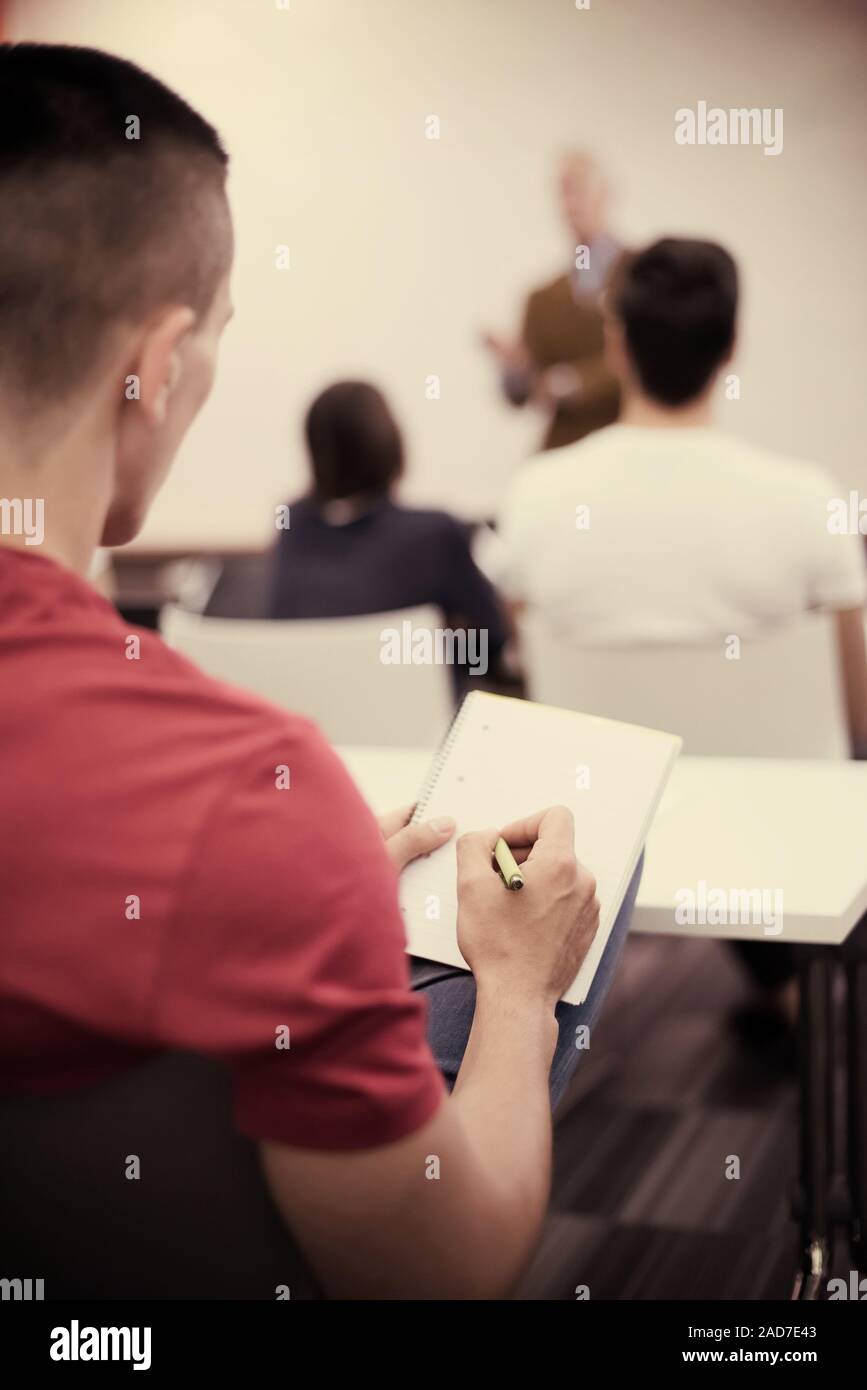 male student taking notes in classroom Stock Photo - Alamy