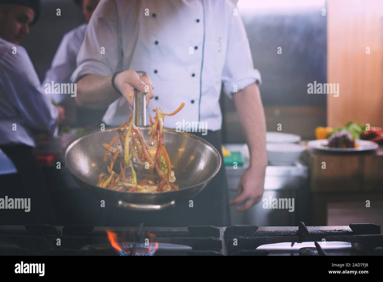 chef flipping vegetables in wok Stock Photo - Alamy