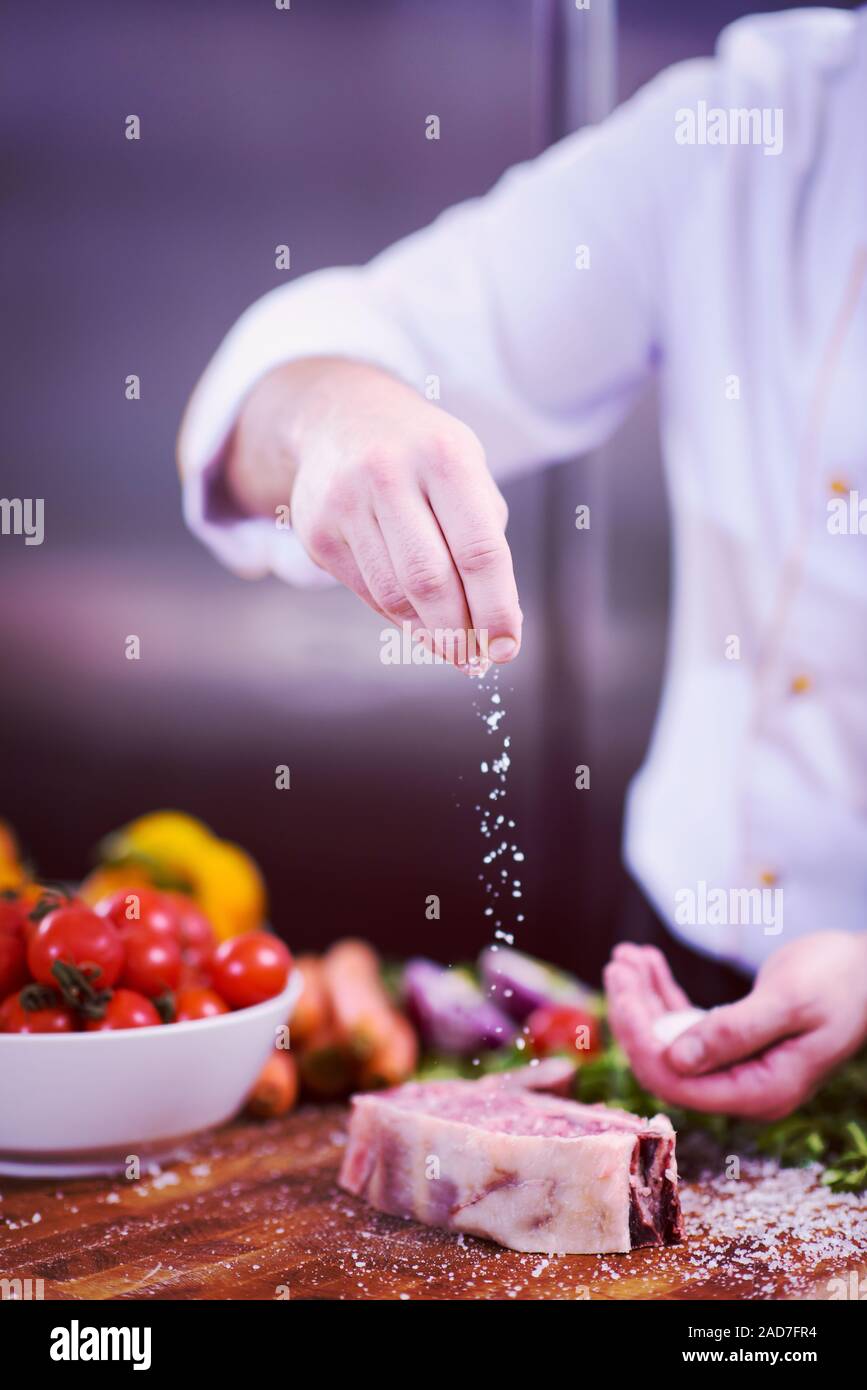 Chef putting salt on juicy slice of raw steak Stock Photo - Alamy