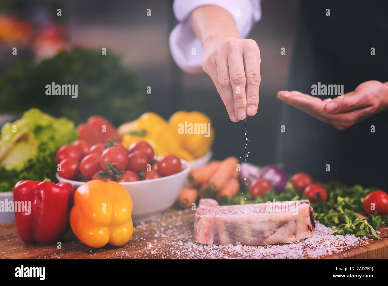 Chef putting salt on juicy slice of raw steak Stock Photo - Alamy