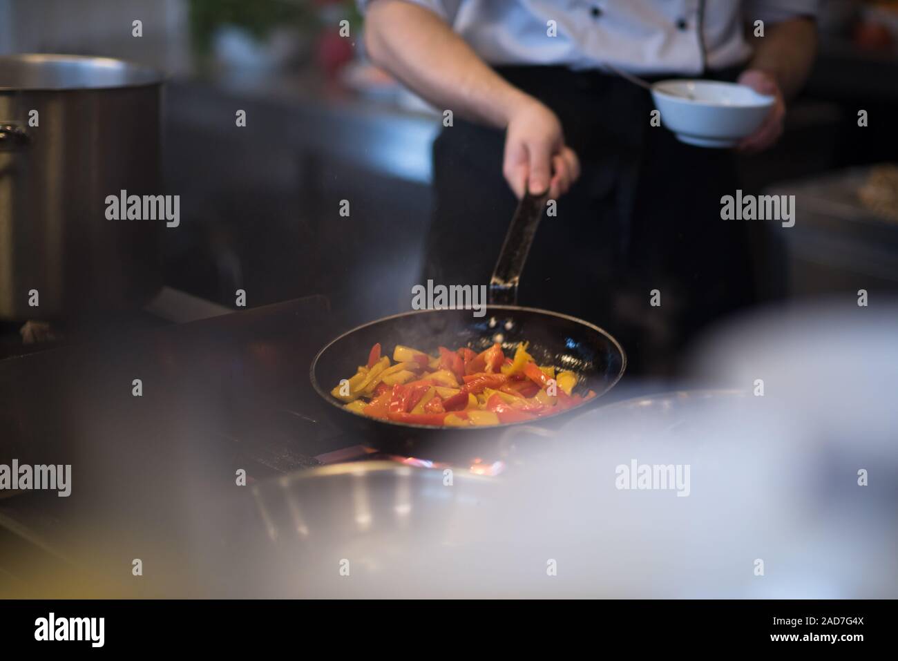 chef flipping vegetables in wok Stock Photo - Alamy