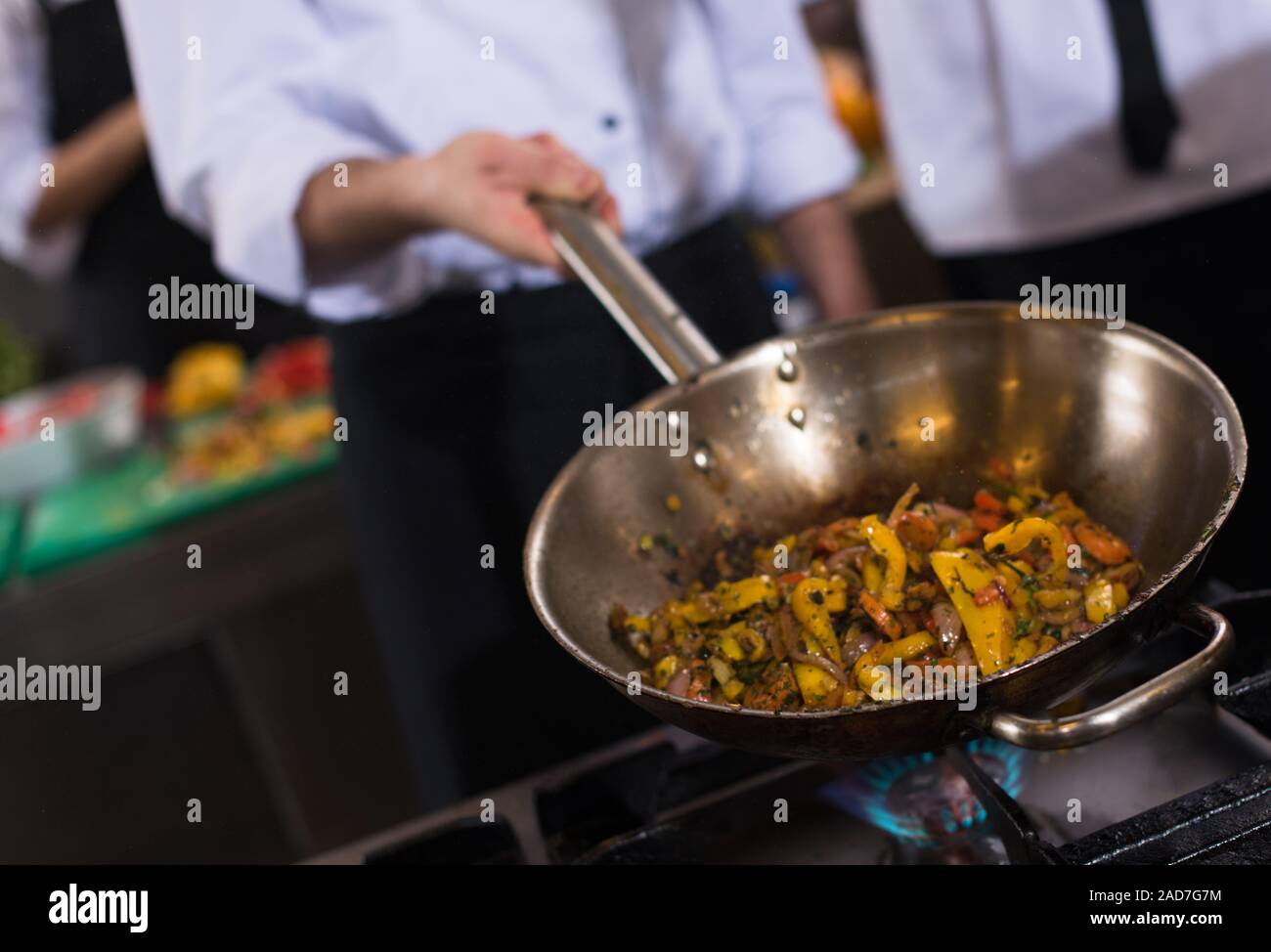 chef flipping vegetables in wok Stock Photo - Alamy