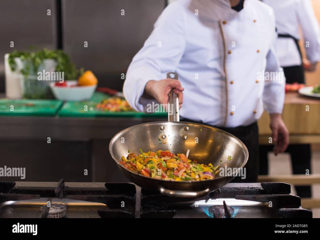 chef flipping vegetables in wok Stock Photo - Alamy