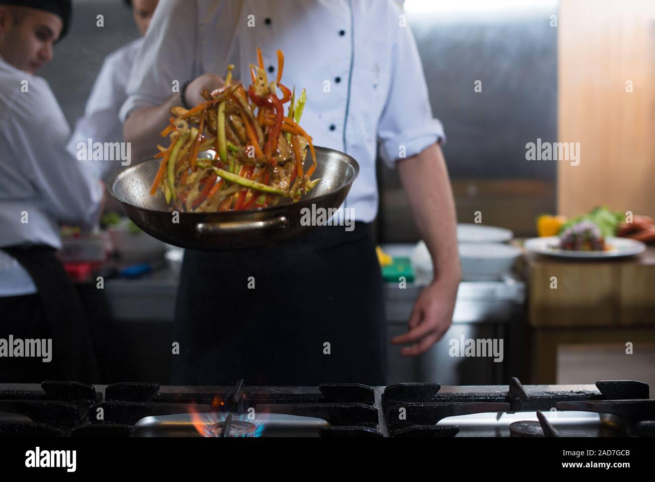 chef flipping vegetables in wok Stock Photo - Alamy