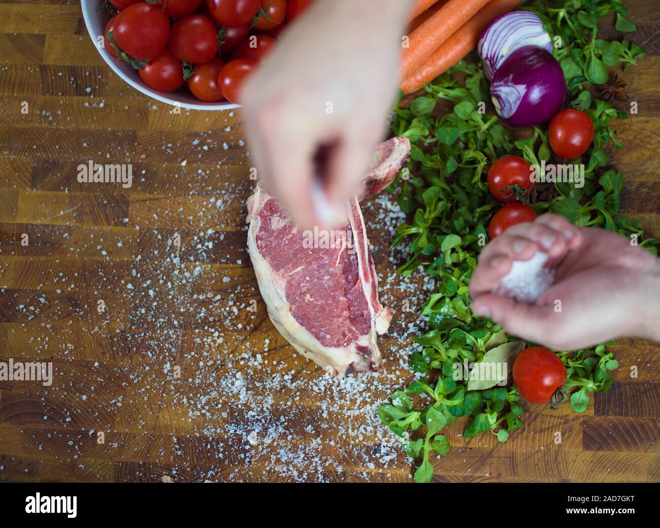 Chef putting salt on juicy slice of raw steak Stock Photo - Alamy