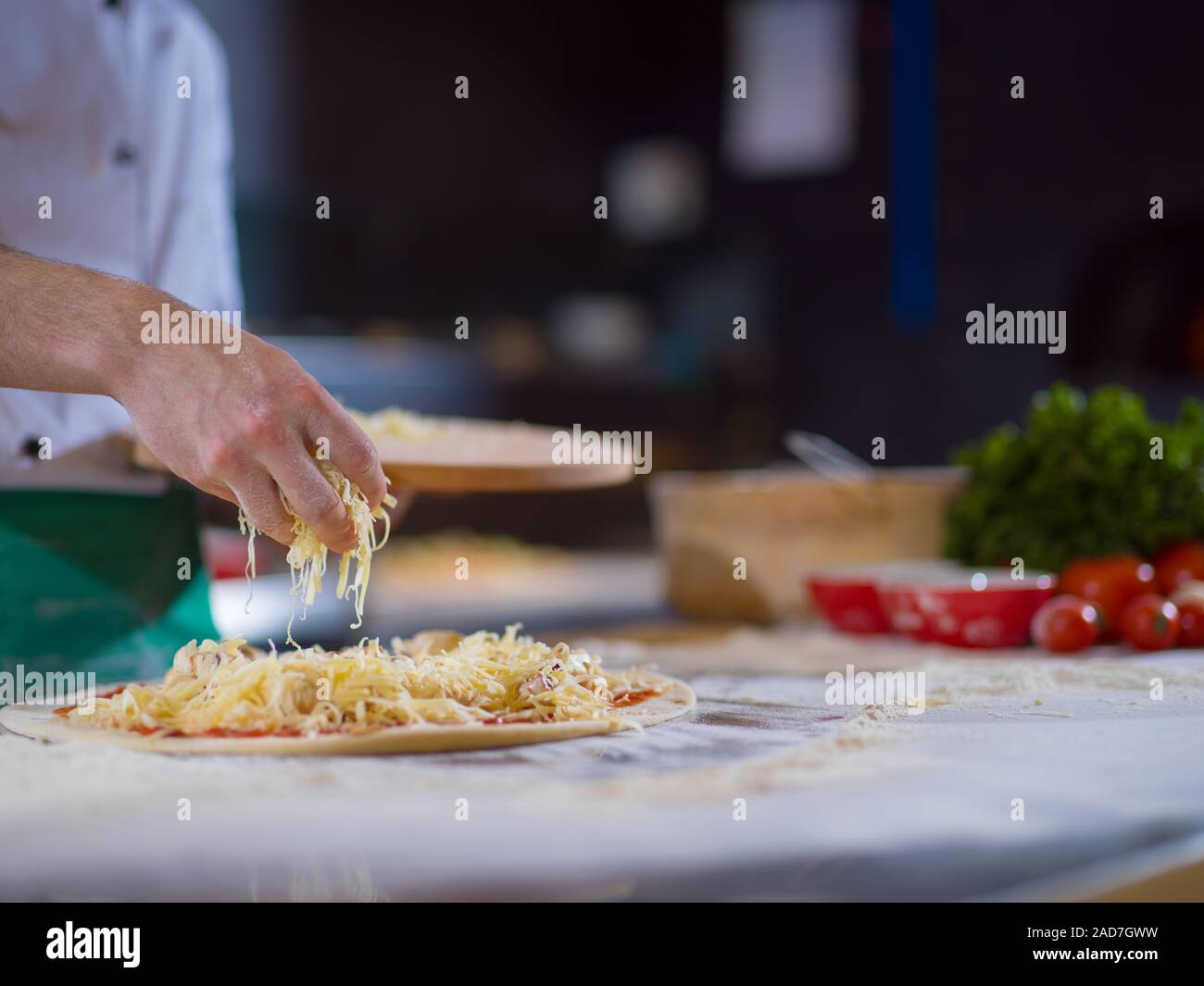 chef sprinkling cheese over fresh pizza dough Stock Photo - Alamy