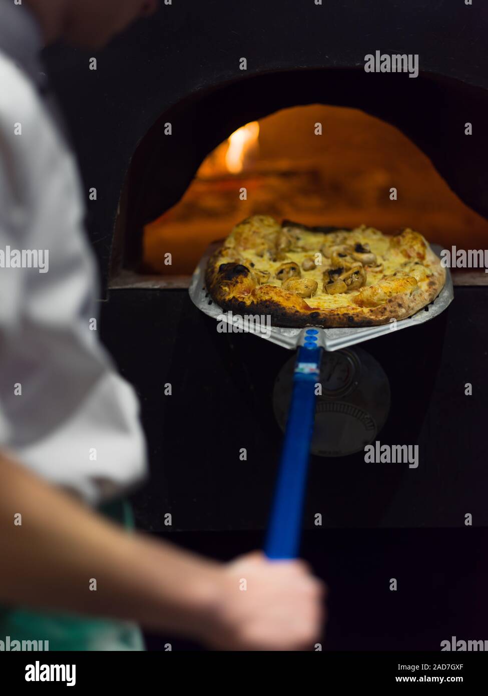 chef removing hot pizza from stove Stock Photo - Alamy