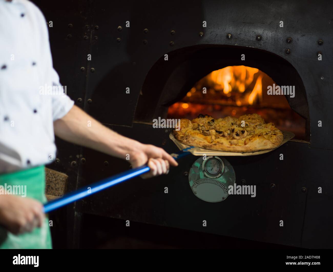 chef removing hot pizza from stove Stock Photo - Alamy