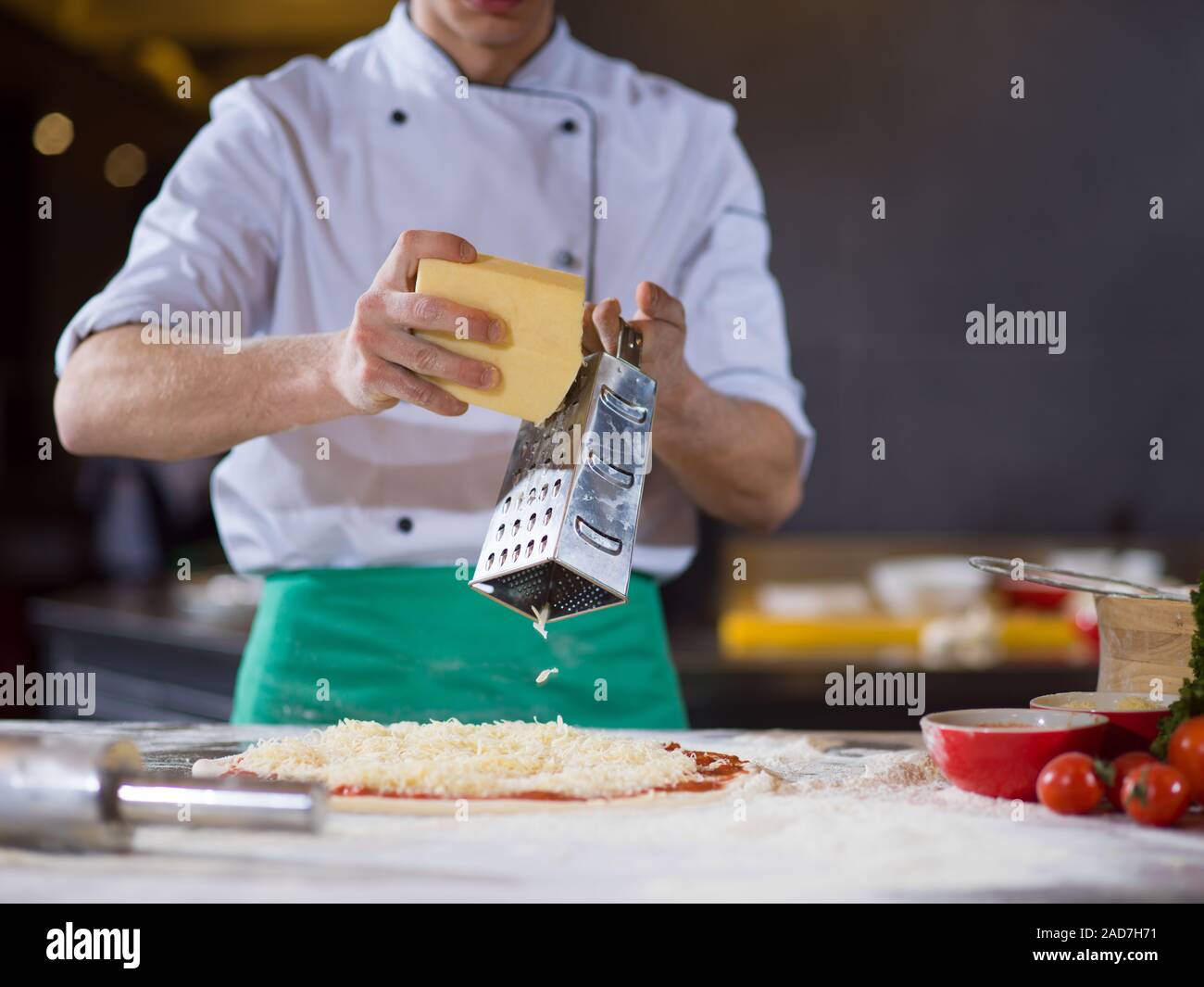 chef sprinkling cheese over fresh pizza dough Stock Photo - Alamy