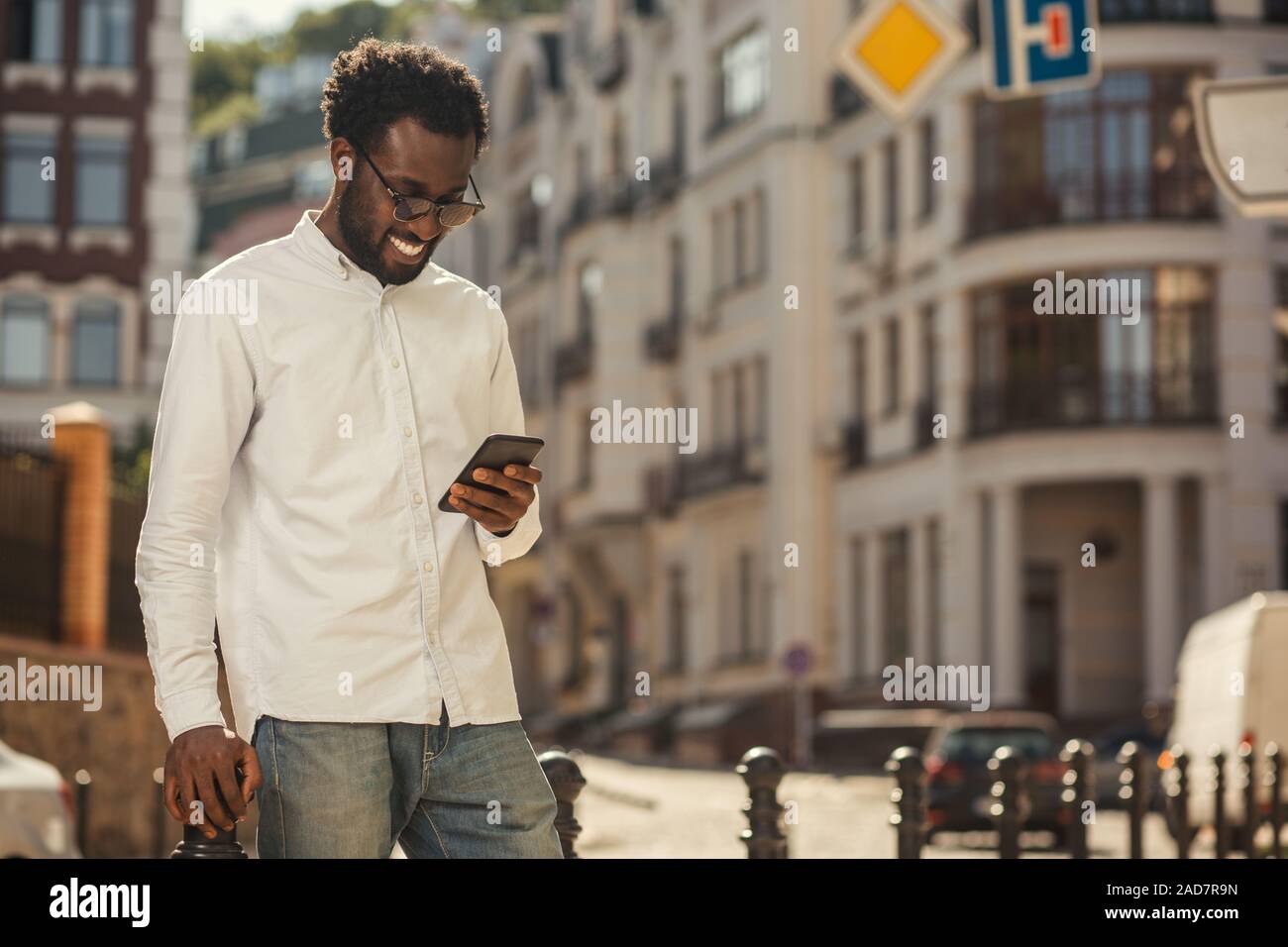 Happy man looking at his smartphone and laughing Stock Photo - Alamy