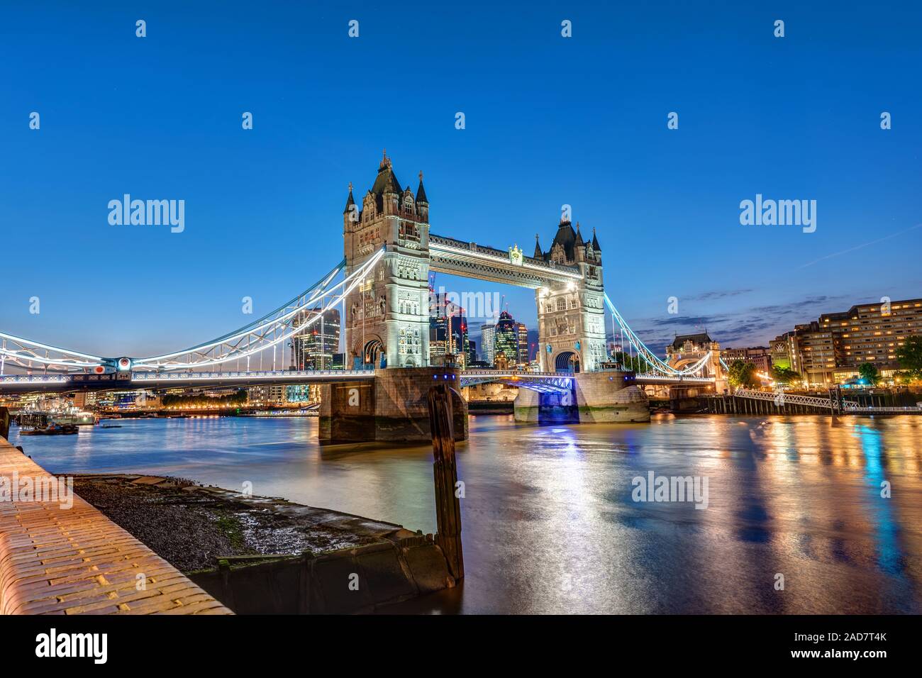The Tower Bridge in London at night with the City in the back Stock ...