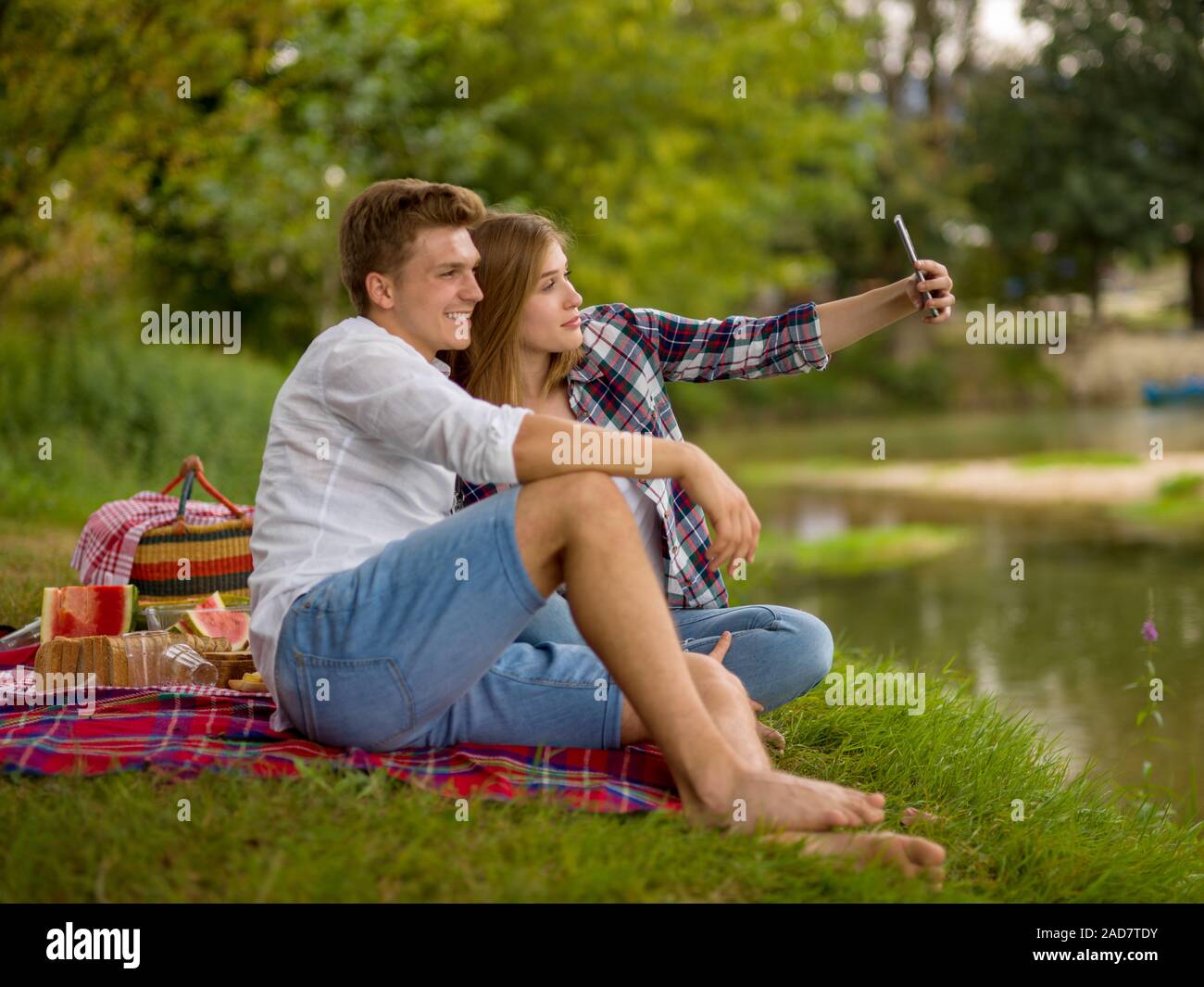 Couple taking a selfie by mobile phone while enjoying picnic time Stock ...