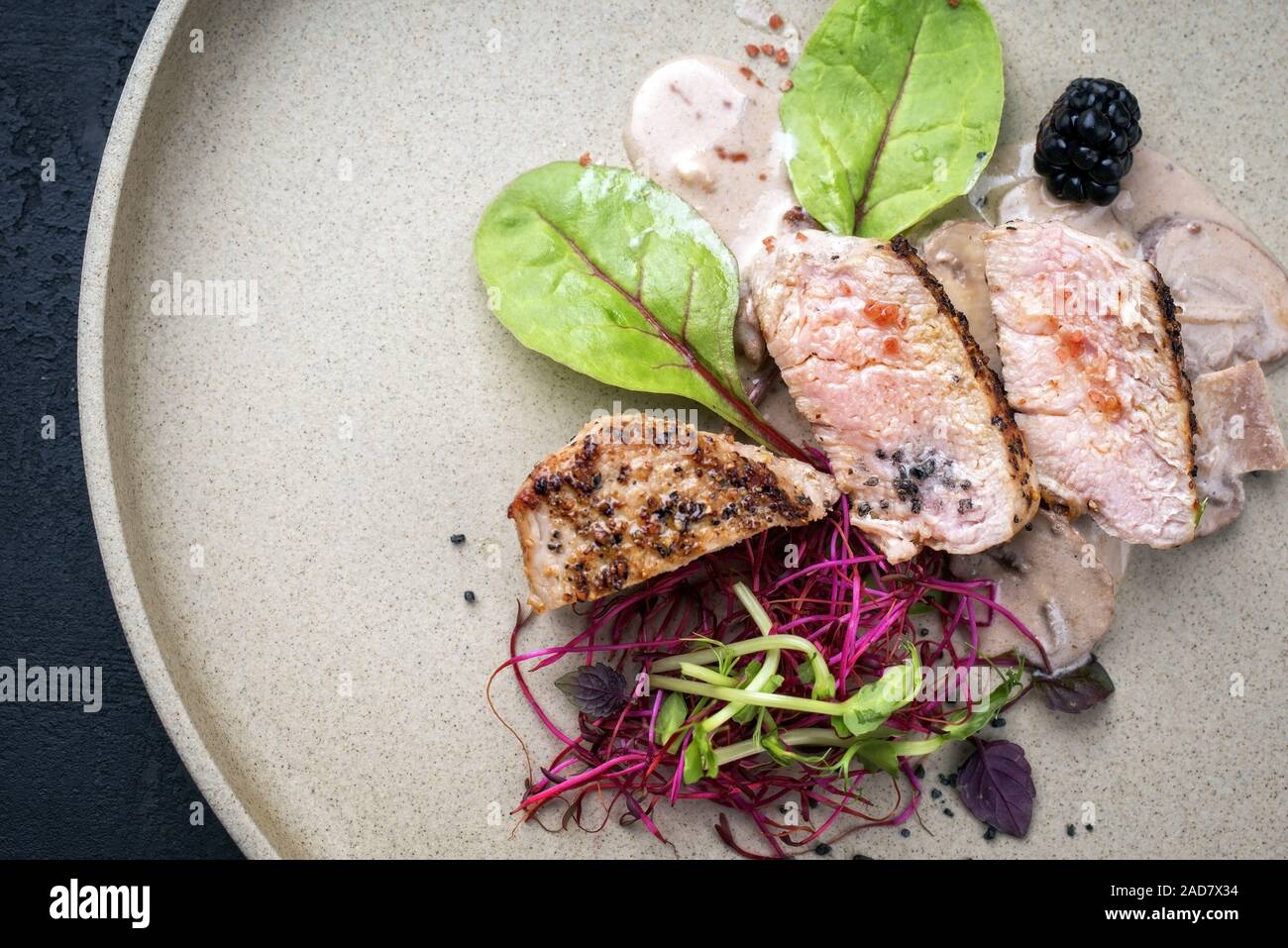 Fried pork fillet with salad and fruits as top view on a plate with ...