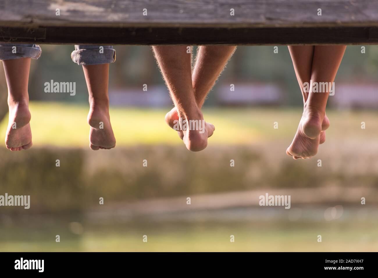 people sitting at wooden bridge Stock Photo - Alamy