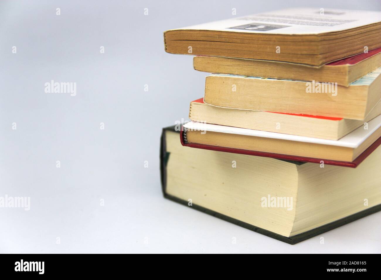A pile of thick books on a table with white background with copy space ...