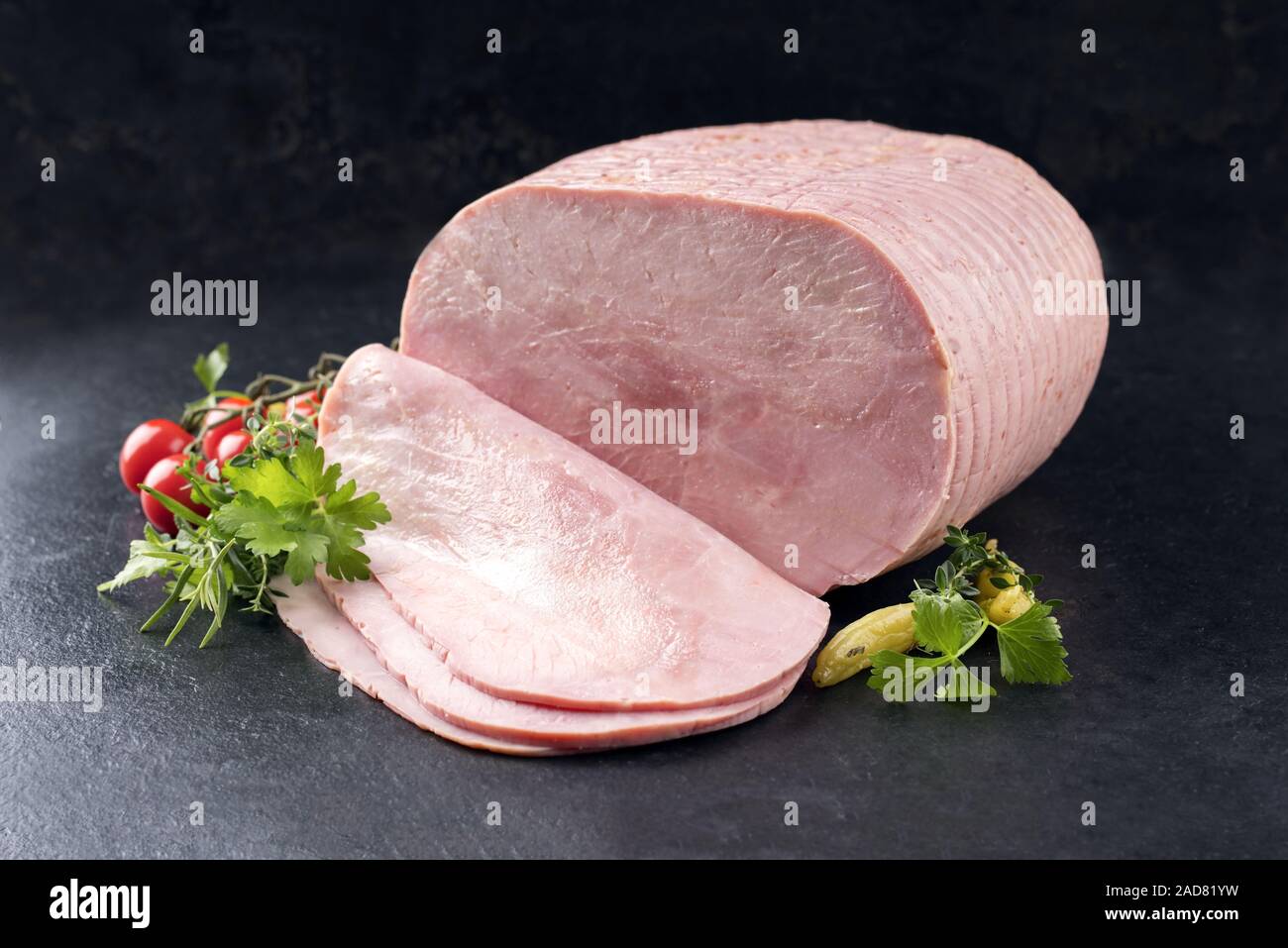Traditional German boiled ham as piece and sliced decorated with ...